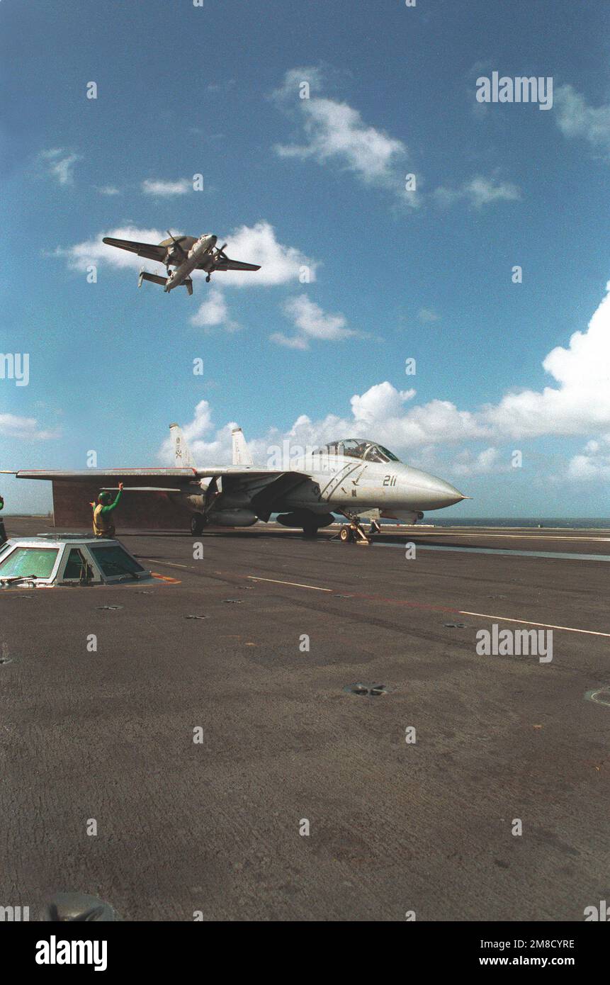 An E-2C Hawkeye aircraft passes overhead as a Fighter Squadron 84 (VF ...