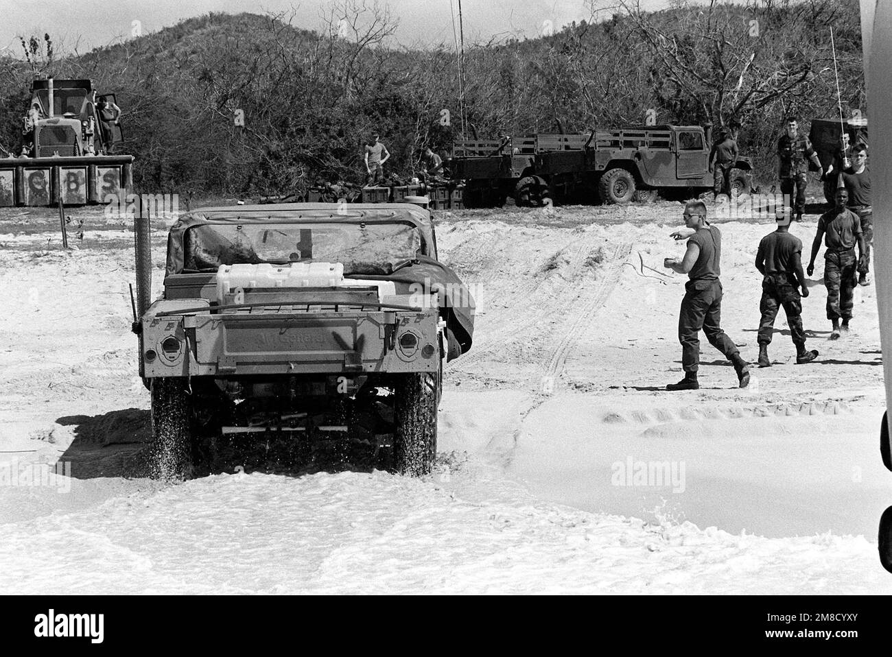 A Marine directs the driver of an M998 High-Mobility Multipurpose ...