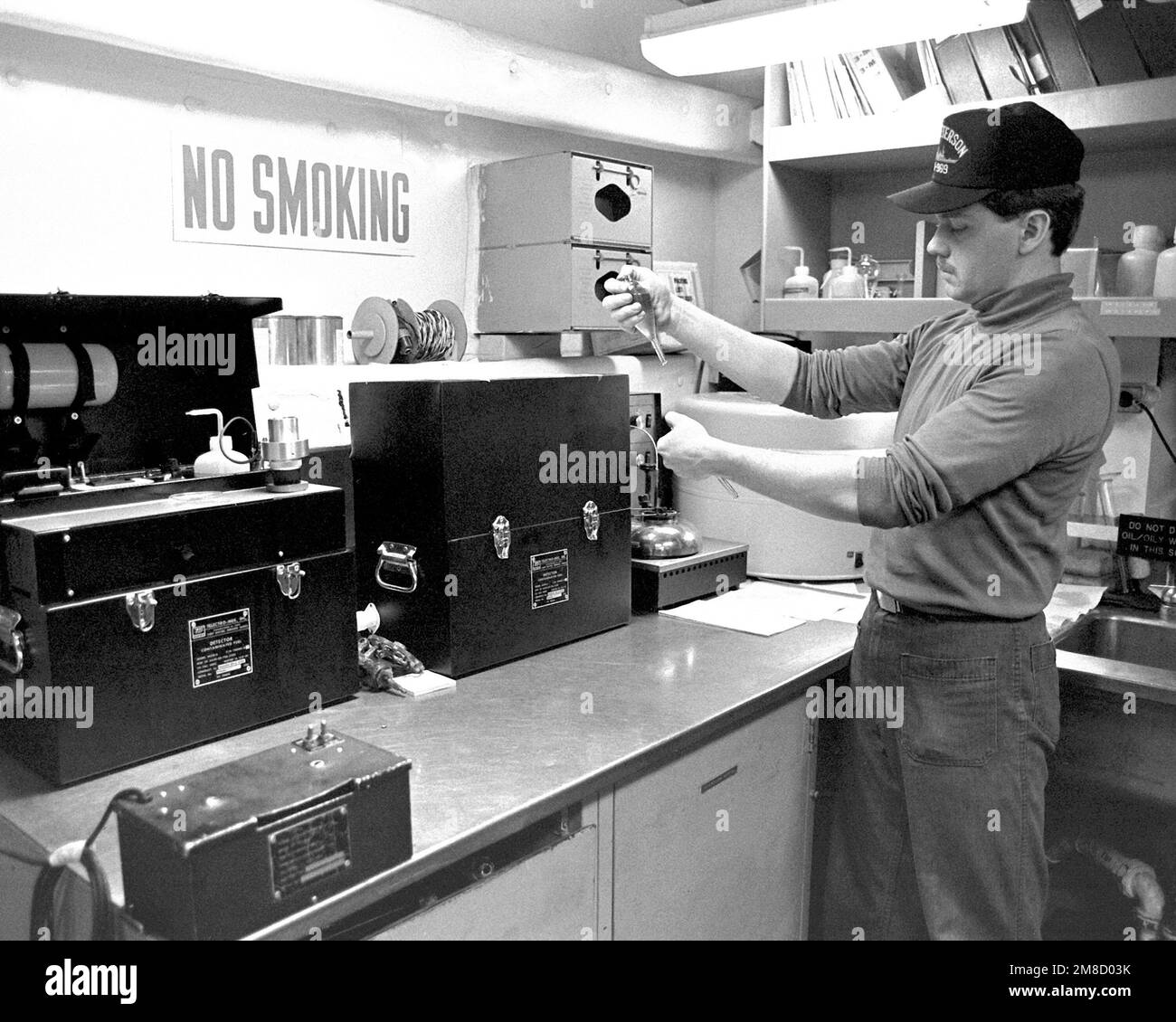 A crew member aboard the destroyer USS PETERSON (DD-969) inspects fuel ...