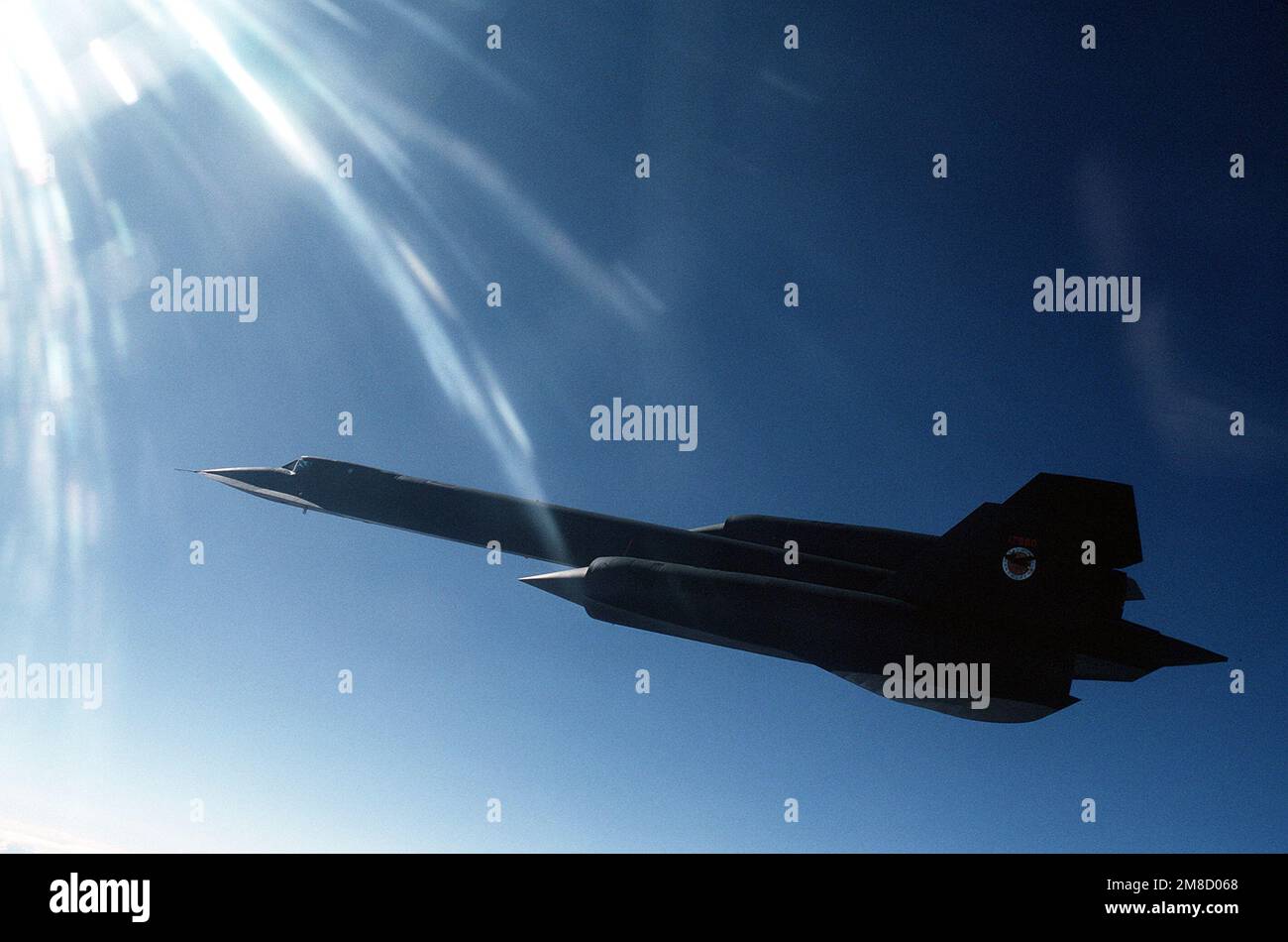 An air-to-air left side view of an SR-71 aircraft. Country: Unknown ...