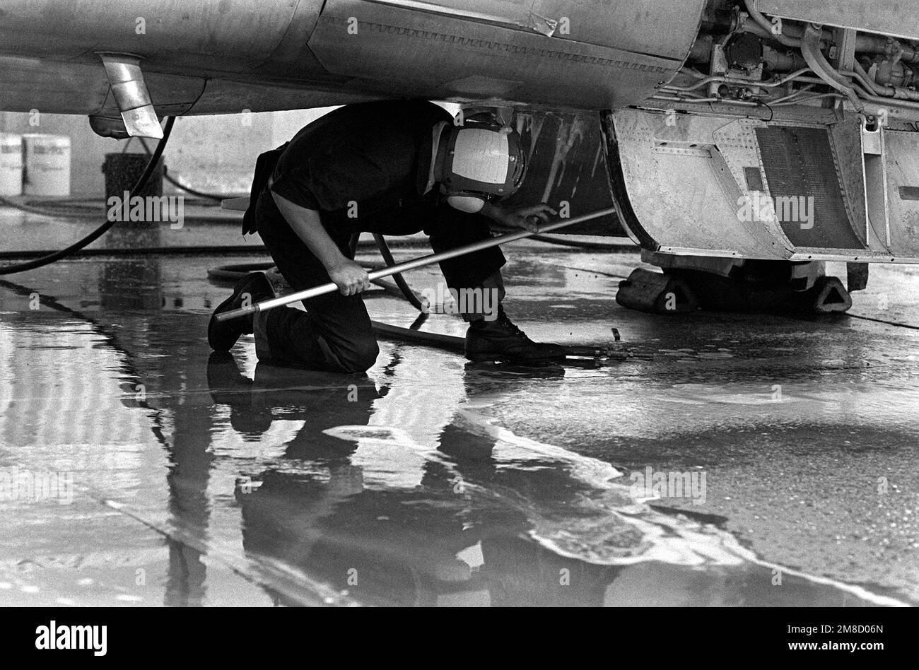 A ground crewman cleans an Attack Squadron 122 (VA-122) A-7E Corsair II ...