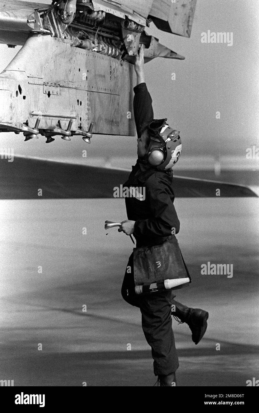 A member of Attack Squadron 122 (VA-122) performs a preflight ...