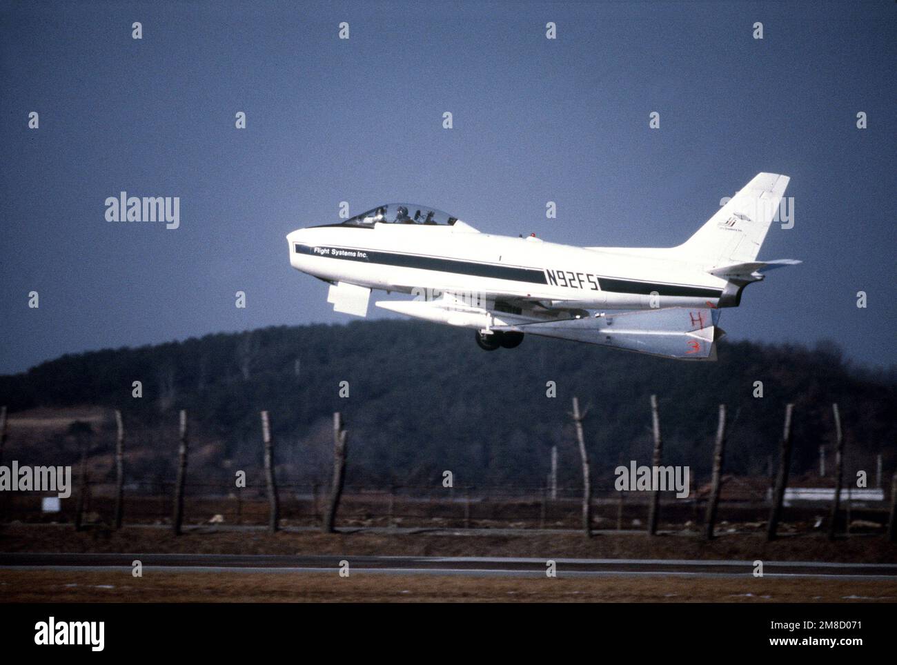 An F-86 Sabre aircraft with target dart attached takes off from base ...