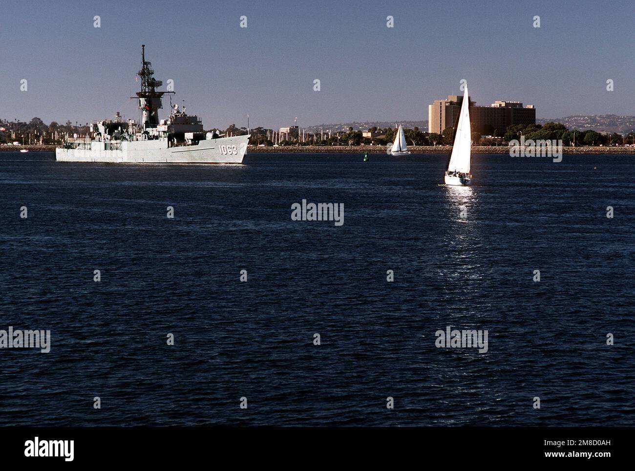 Pleasure craft sail near the frigate USS REASONER (FF-1063). Base: San ...