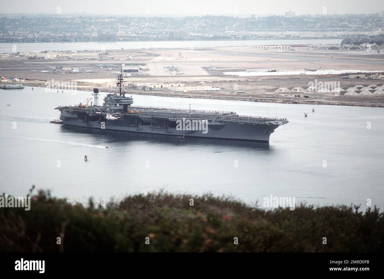 Crew members man the rails as the aircraft carrier USS CONSTELLATION ...