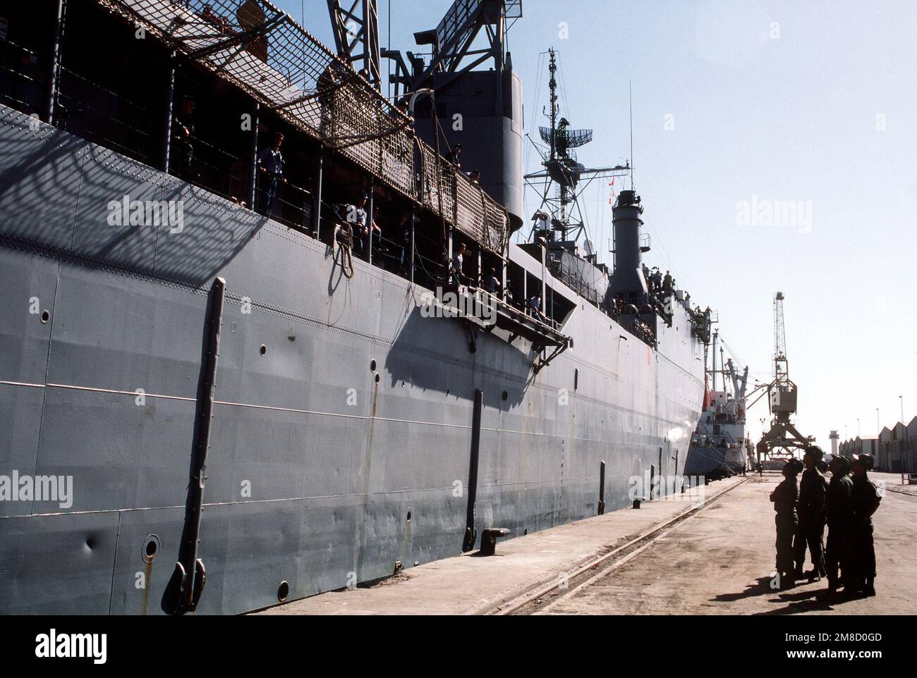 Tunisian dock workers watch as the dock landing ship USS PORTLAND (LSD ...