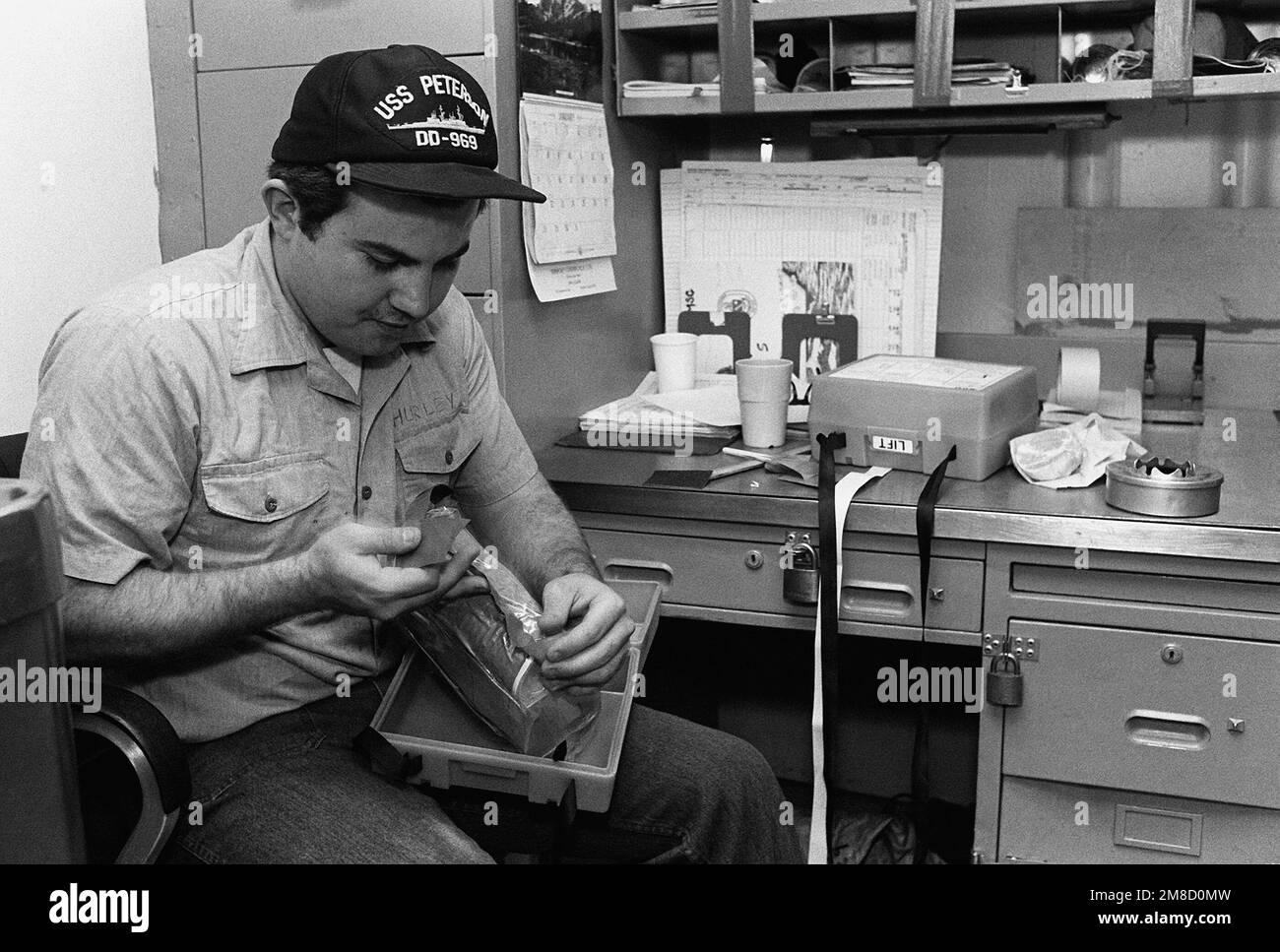 A crewman aboard the destroyer USS PETERSON (DD-969) inspects Emergency ...
