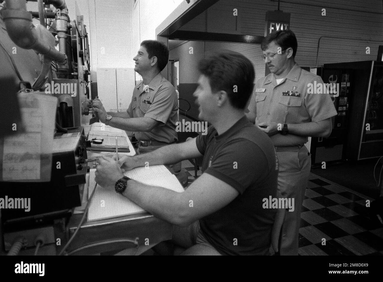 Naval personnel work at the control panel for the decompression chamber ...