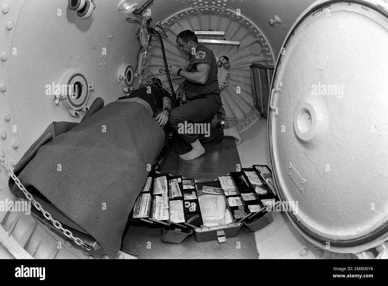 Hospital Corpsman 1ST Class (Diver) Raymond Gwaltney examines a patient ...