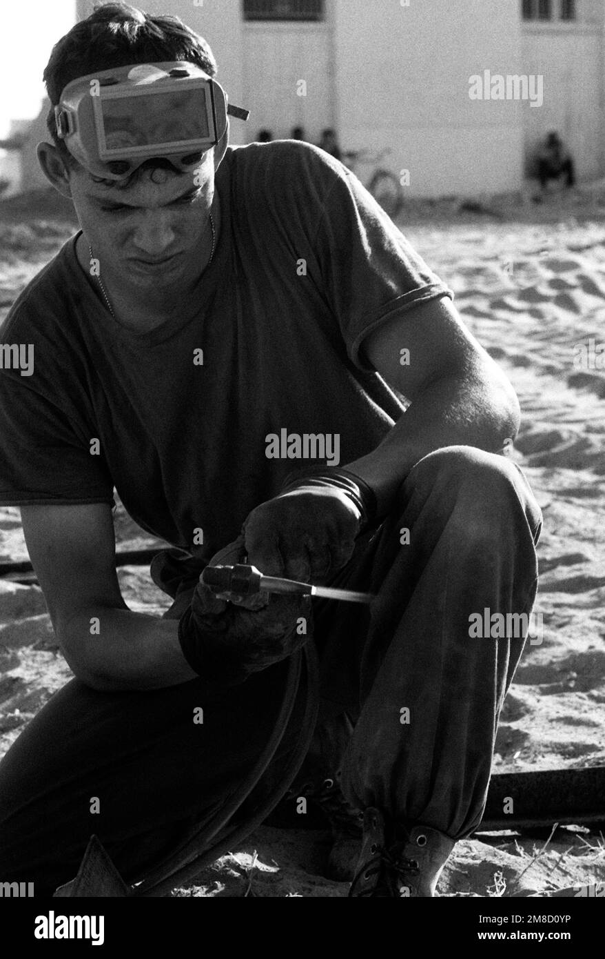 A US Navy Seabee checks his welding torch during setup of the Seabee's ...