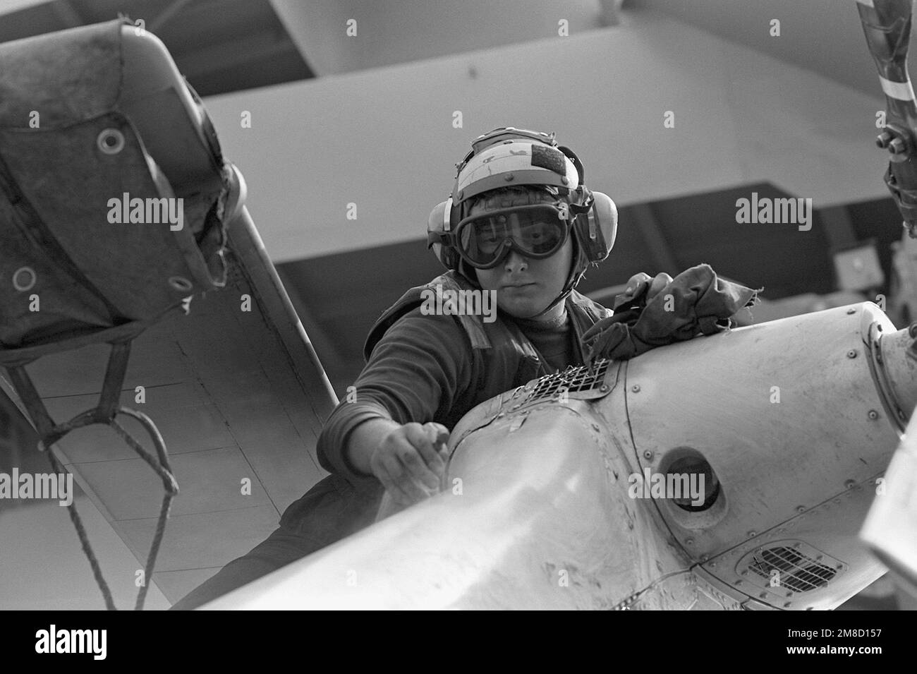 A plane captain wipes down the tail section of an SH-3H Sea King ...