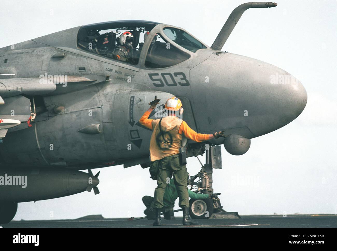 A plane director signals to the pilot of an A-6E Intruder aircraft on ...