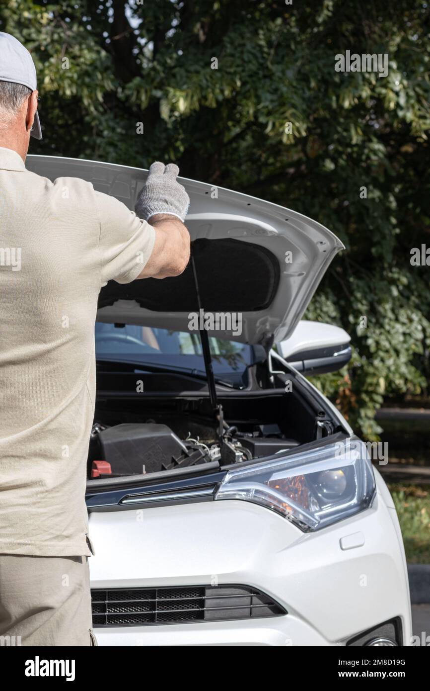 the master opens the hood of the car. man inspecting a car engine. the ...