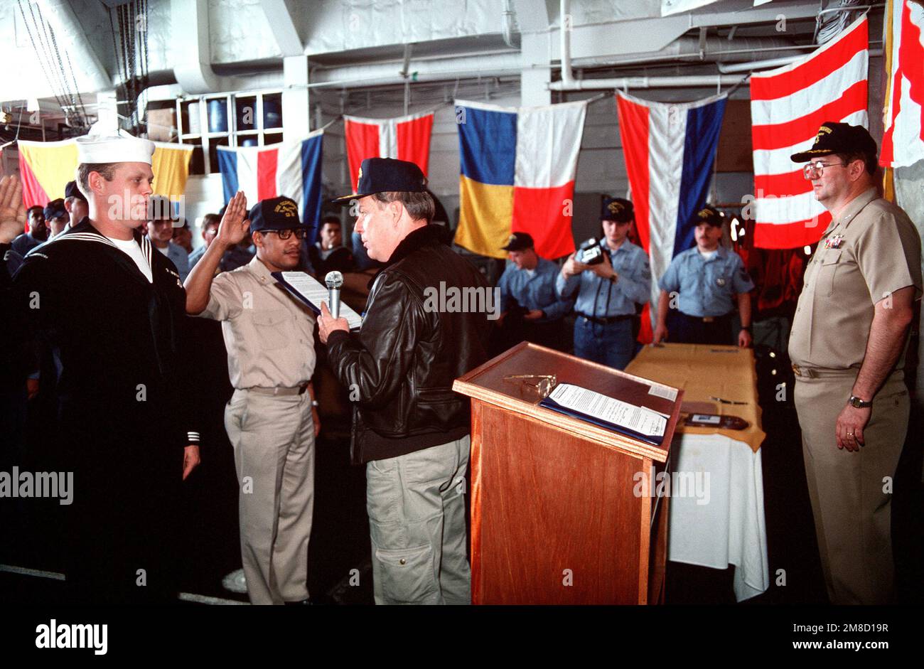 Secretary of the Navy H. Lawrence Garrett III, administers the oath of ...