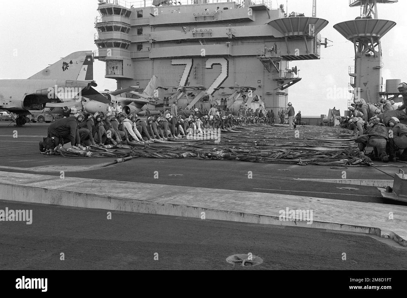 Crewmen stretch the crash barricade across the flight deck of the ...