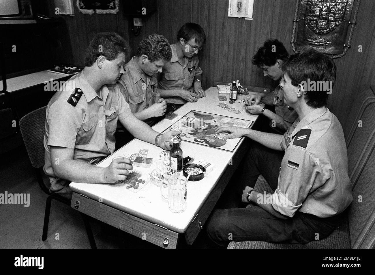 Off-duty sailors play a board game in the enlisted mess aboard the West ...