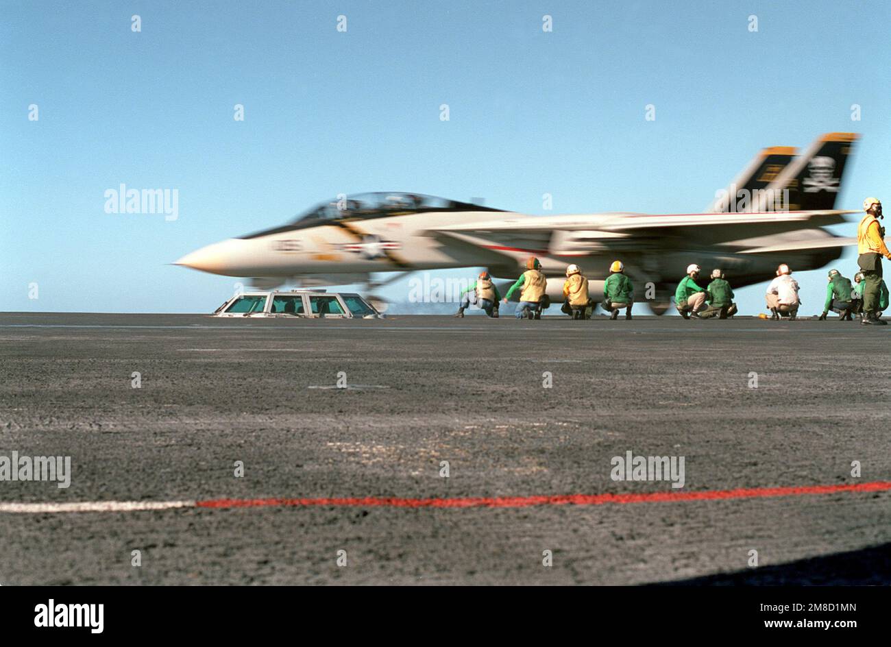 Flight deck crewmen watch as a Fighter Squadron 84 (VF-84) F-14A Tomcat ...