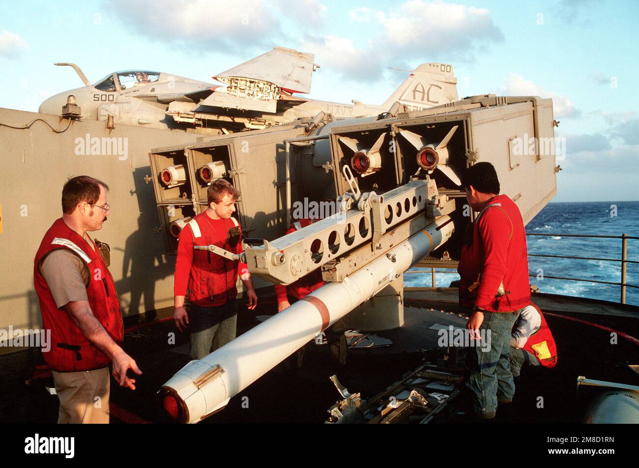 Aviation ordnancemen remove a RIM-7 Sea Sparrow missile from one of the ...