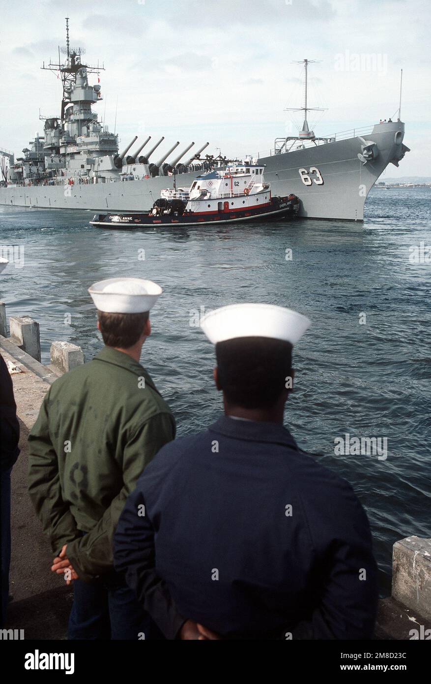 Sailors watch from the pier as the commercial tug CHERYL ANNE maneuver ...
