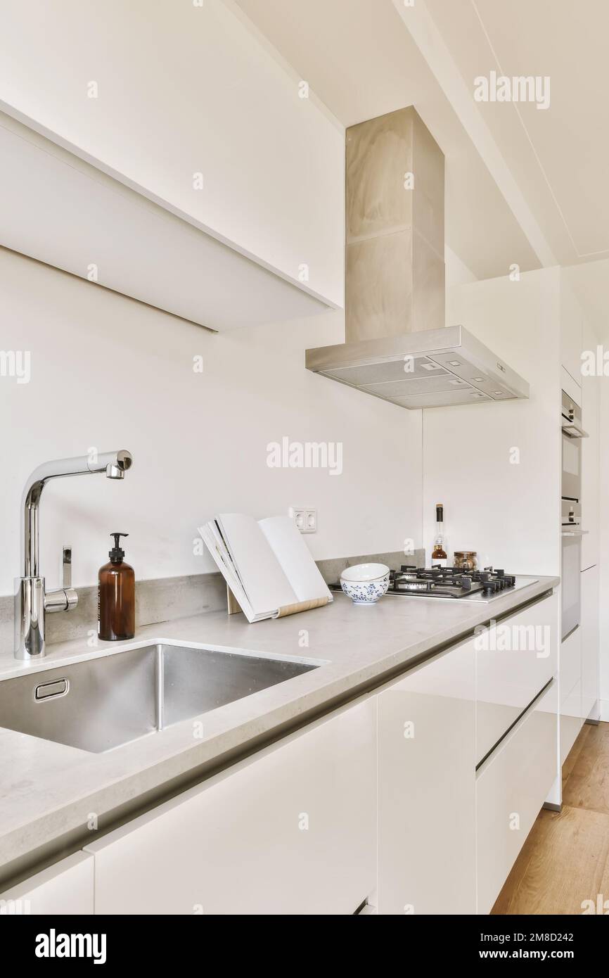 a modern kitchen with white cabinets and stainless steel appliances on ...