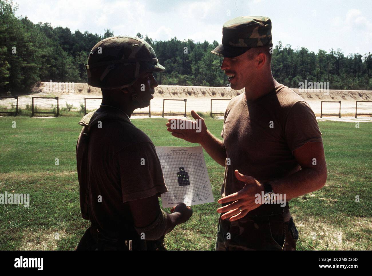An instructor and a recruit review the recruit's rifle qualification ...