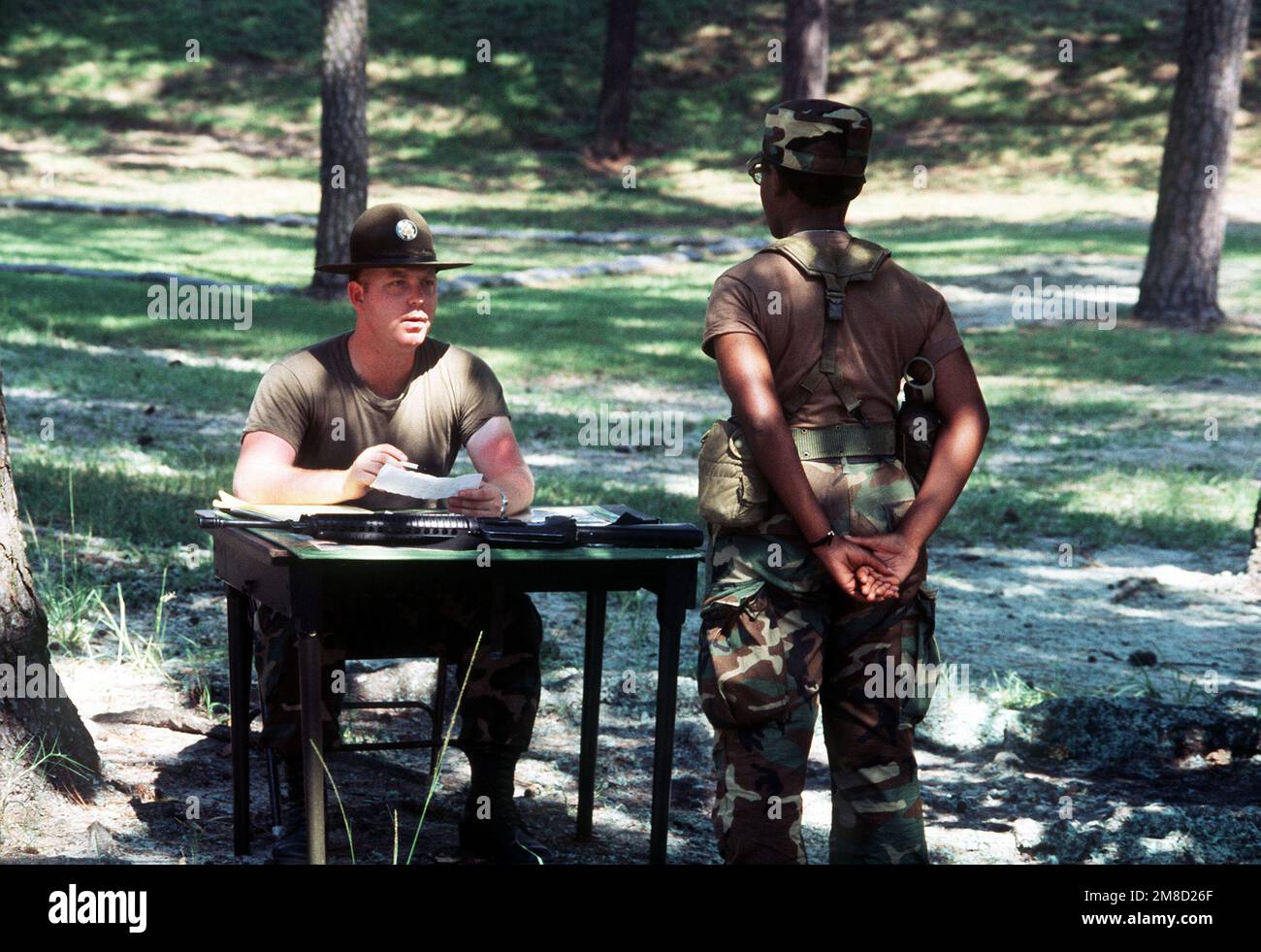 A drill instrcutor and a recruit review the recruit's performance score ...