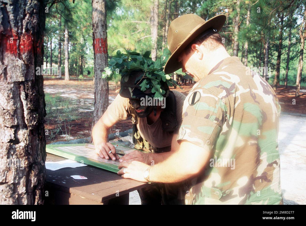 An instructor oversees a soldier completing the map orientation segment ...