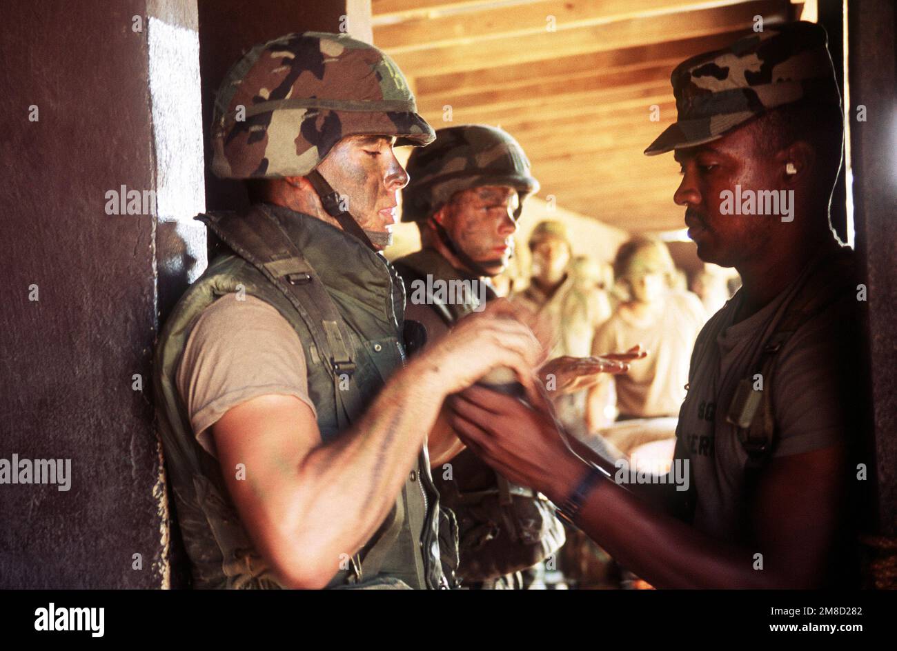 An instructor demonstrates the handling of a grenade to a recruit ...