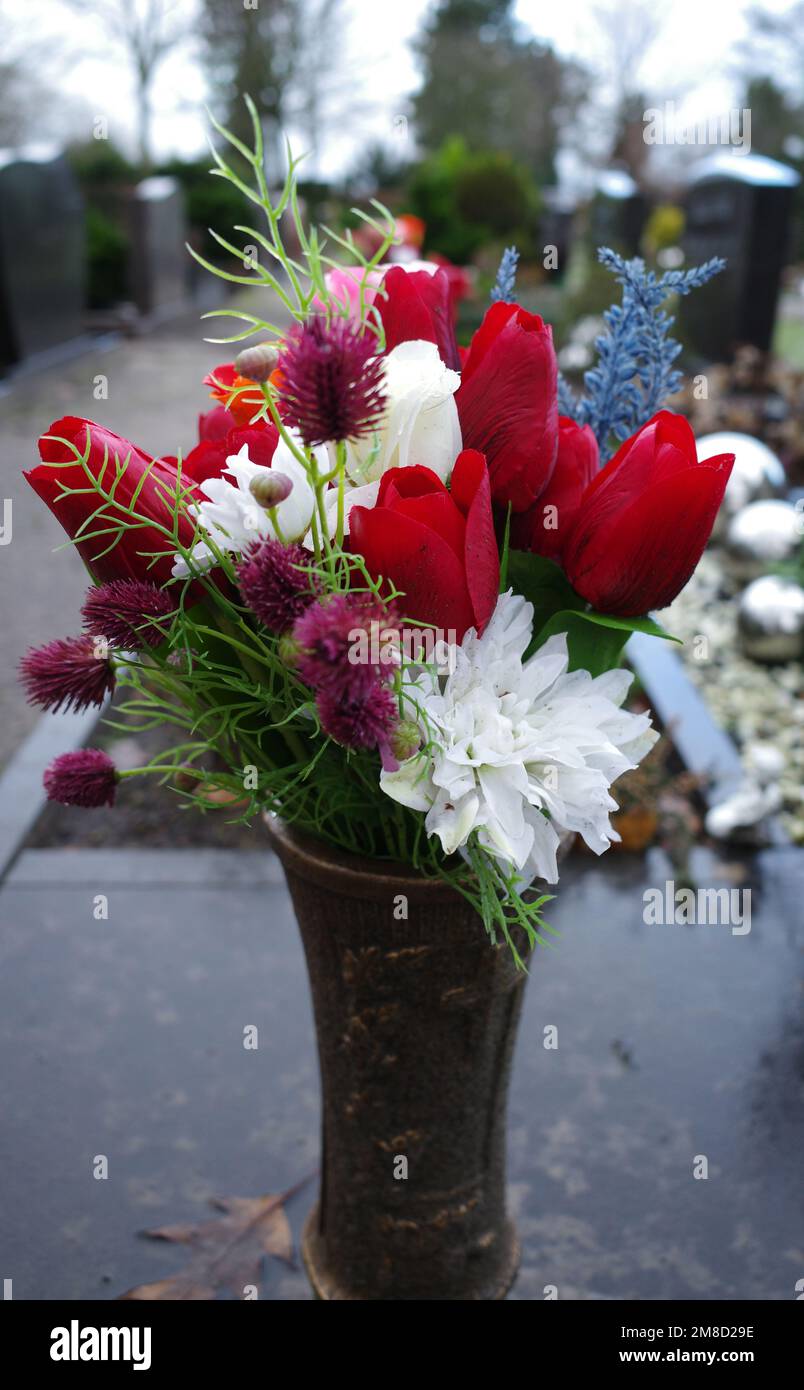 Bouquet of fresh flowers on a tombstone on a rainy day Stock Photo - Alamy