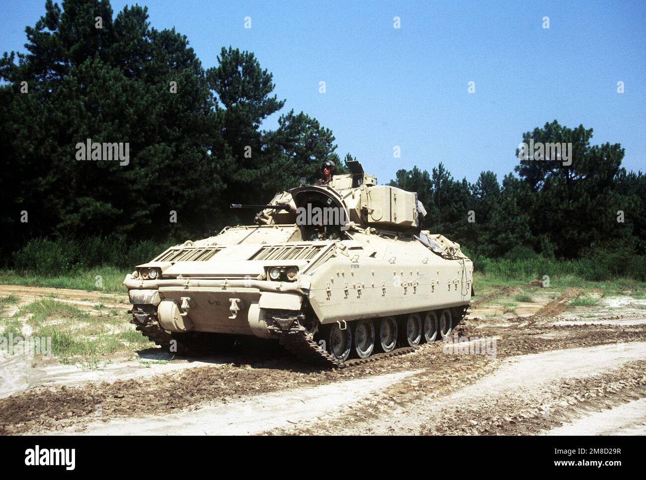 Soldiers operate a desert camouflaged M-2 Bradley infantry fighting ...