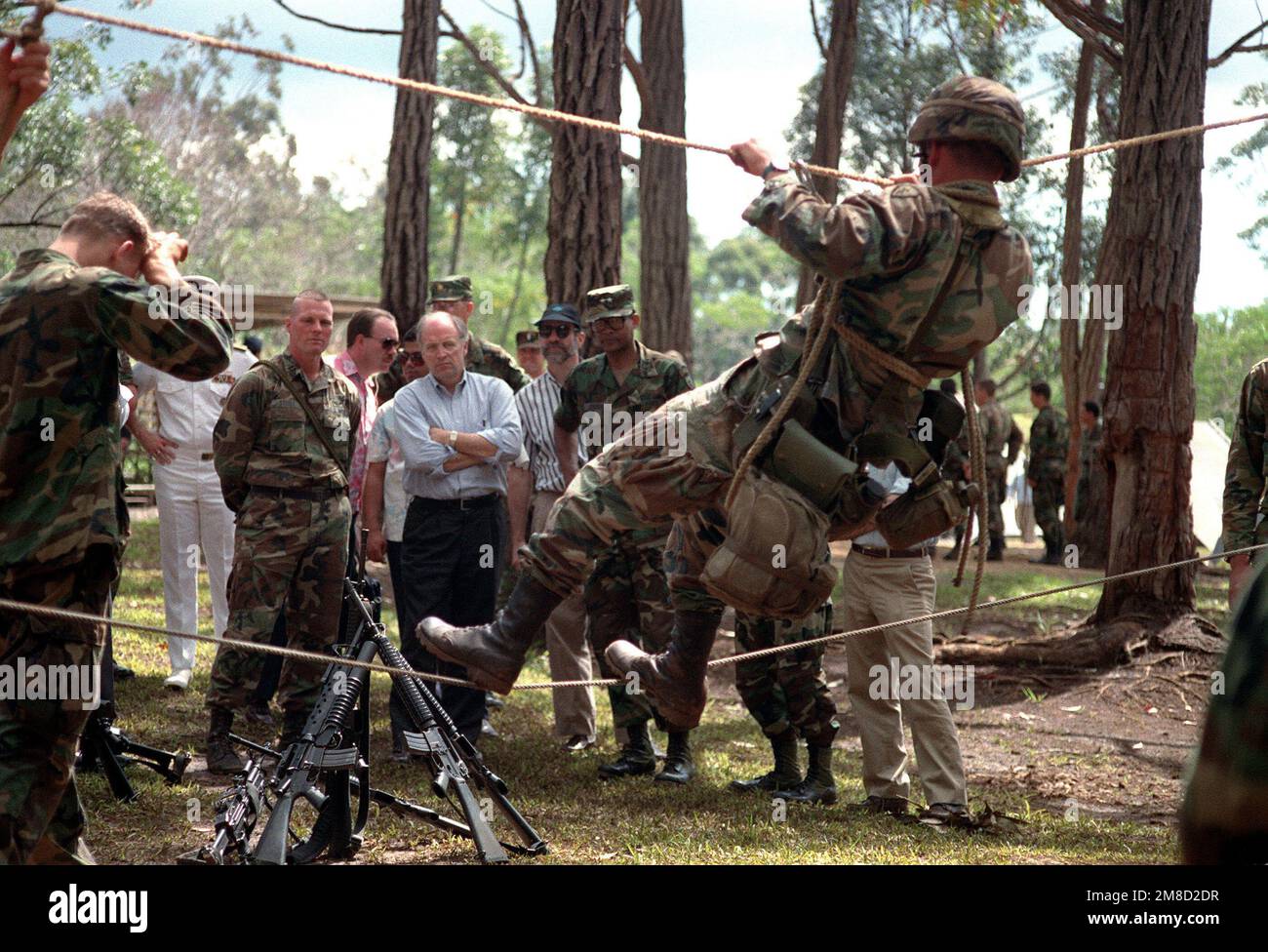 Secretary of Defense Dick Cheney, center, watches a soldier cross a two ...
