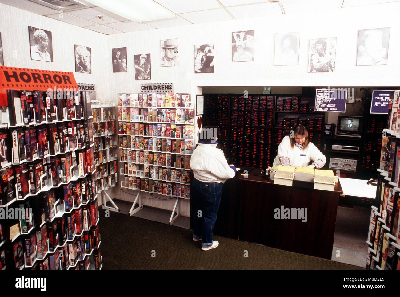 An employee serves a customer in the Truman Plaza video rental ...