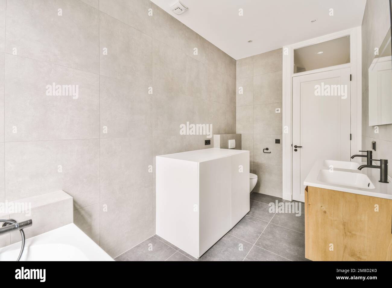 a modern bathroom with grey tile flooring and white fixtures on the ...