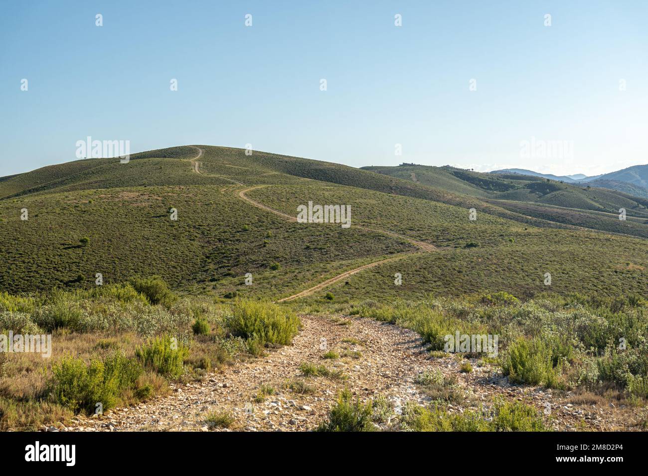 A rural landscape with lush green hillside meadows under blue sky Stock ...