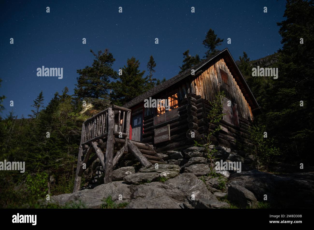 Cabin overlooking cliff backlit by bright, starry blue night sky Stock ...
