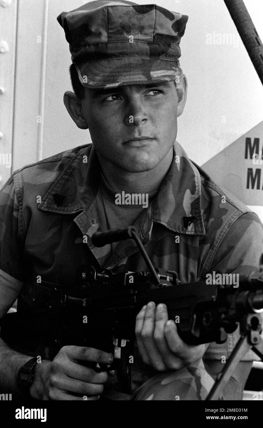 A Marine corporal holds his M-249 squad automatic weapon while embarked ...