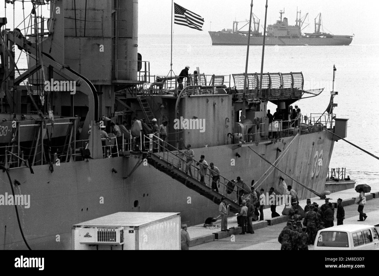 A working party carries bags of mail onto the dock landing ship USS ...