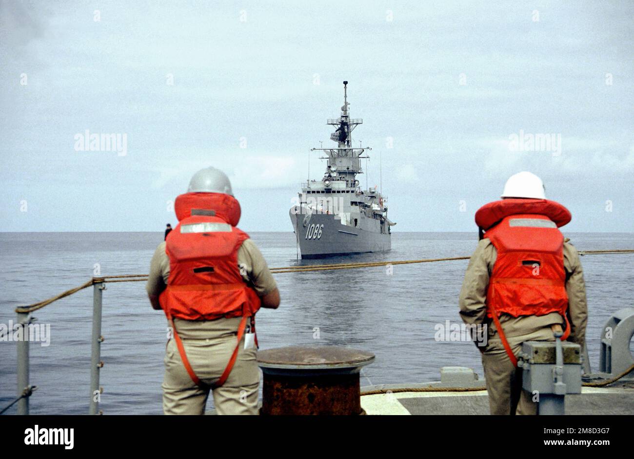 Crew members stand by on the stern of the guided missile destroyer USS ...