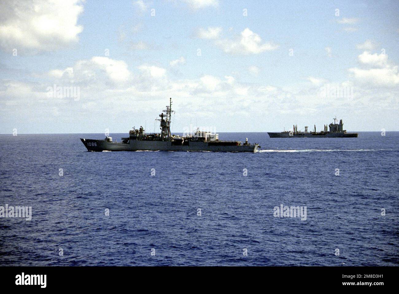 A port beam view of the frigate USS BREWTON (FF-1086), foreground, and ...
