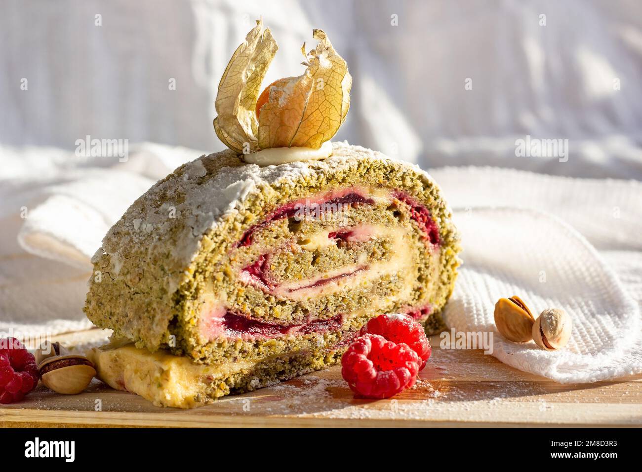 Green pistachio meringue roulade slice with raspberry jelly jam on ...