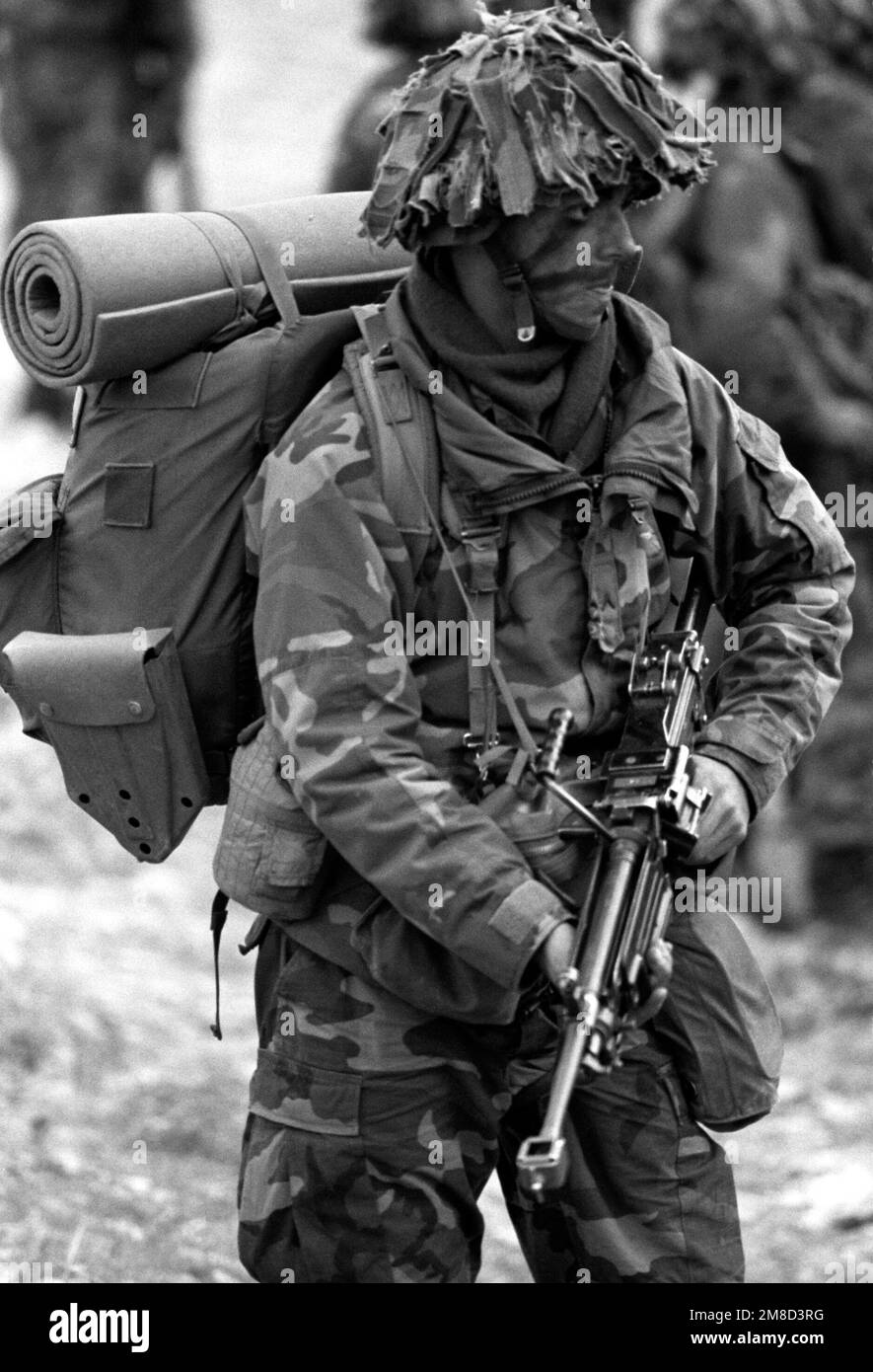 Holding his M-249 squad automatic weapon, a member of the Army's 7th ...