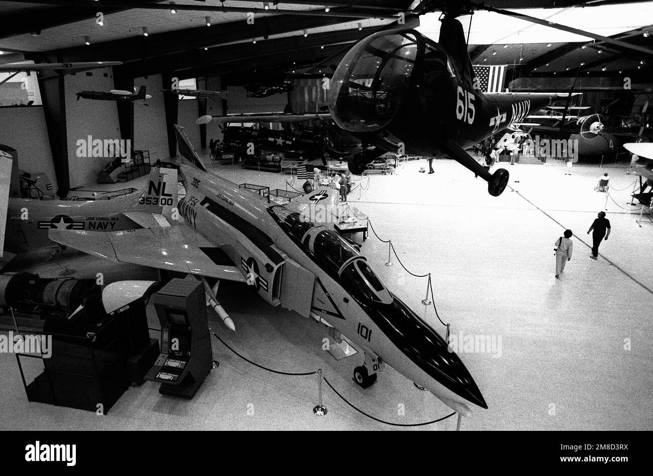 Visitors to the US Naval Aviation Museum walk past an F-4B Phantom II ...