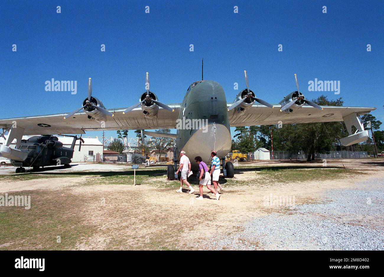Three visitors walk past a PB26-3 Coronado aircraft on display at the ...