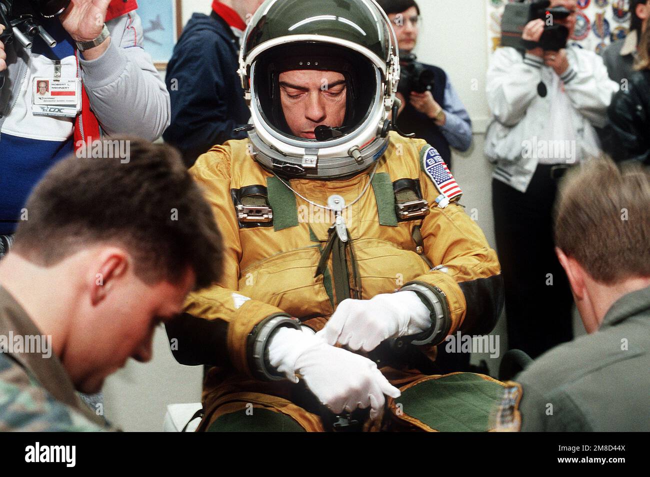 LTC Raymond E. Yeilding, pilot, adjusts his flight suit with the help ...