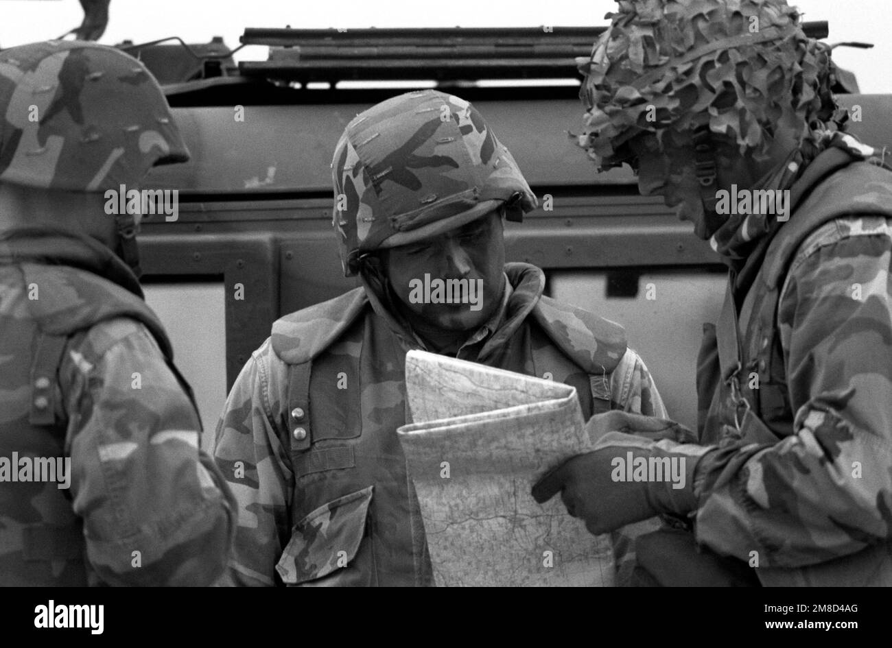 Three Marines review a map before driving inland on D-day of the ...