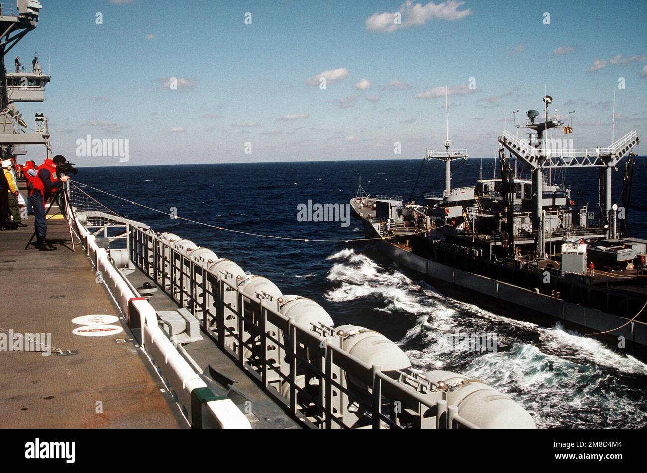 A cameraman on the amphibious assault ship USS WASP (LHD-1) films preparations on the fleet ...