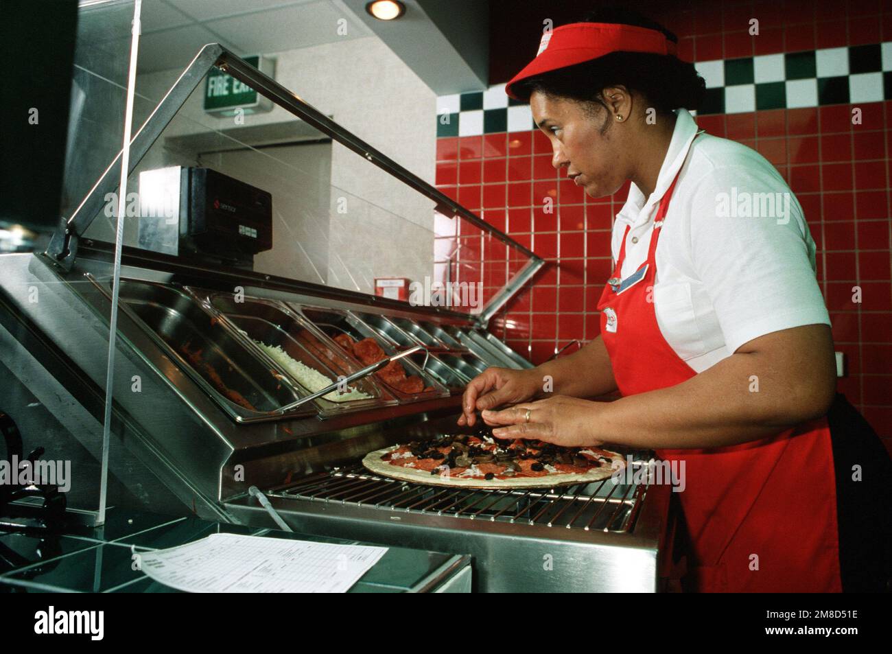 An employee prepares a pizza at the food mall, part of the Army/Air ...