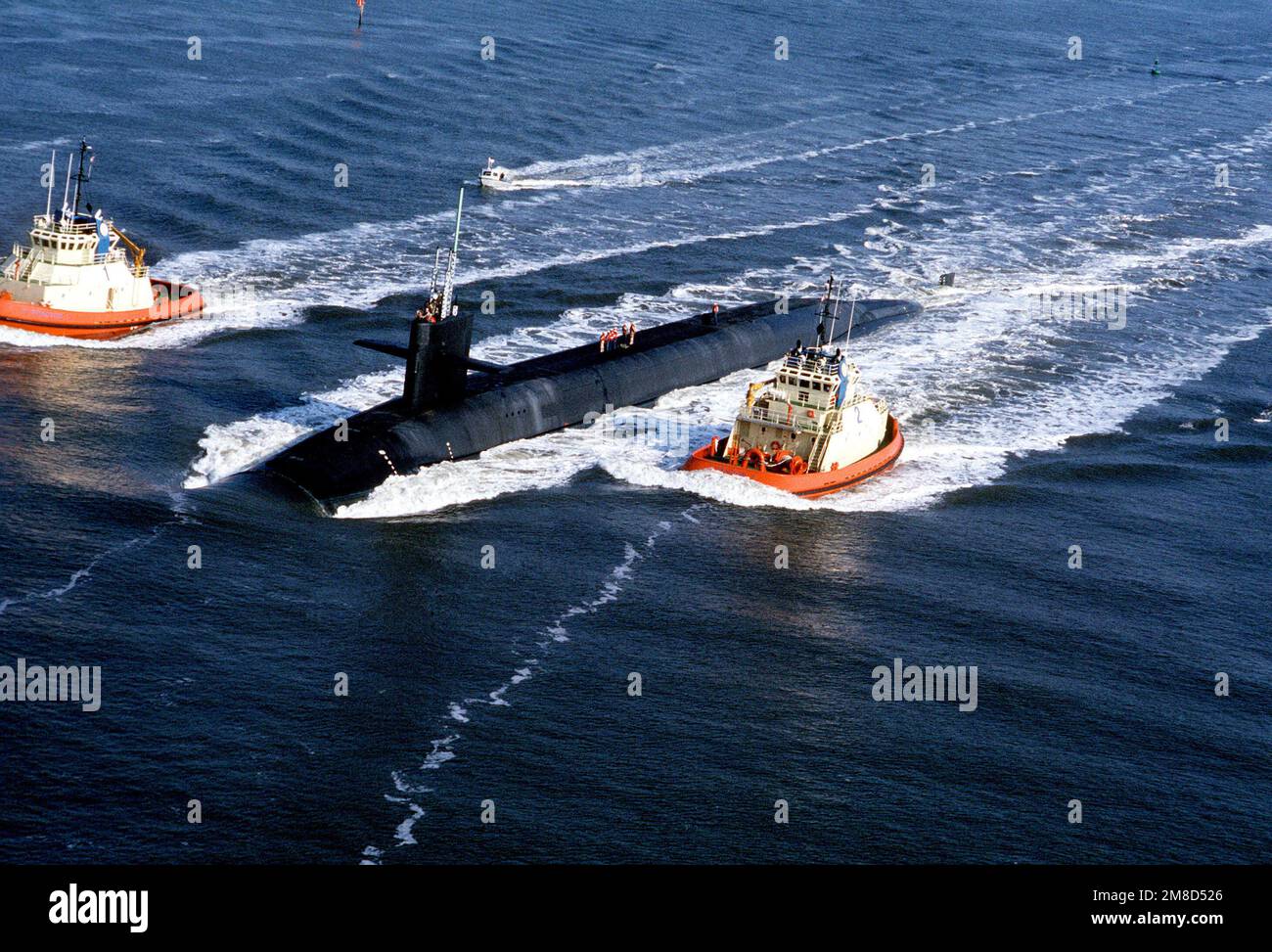 Commercial tugs escort the nuclear-powered strategic missile submarine ...