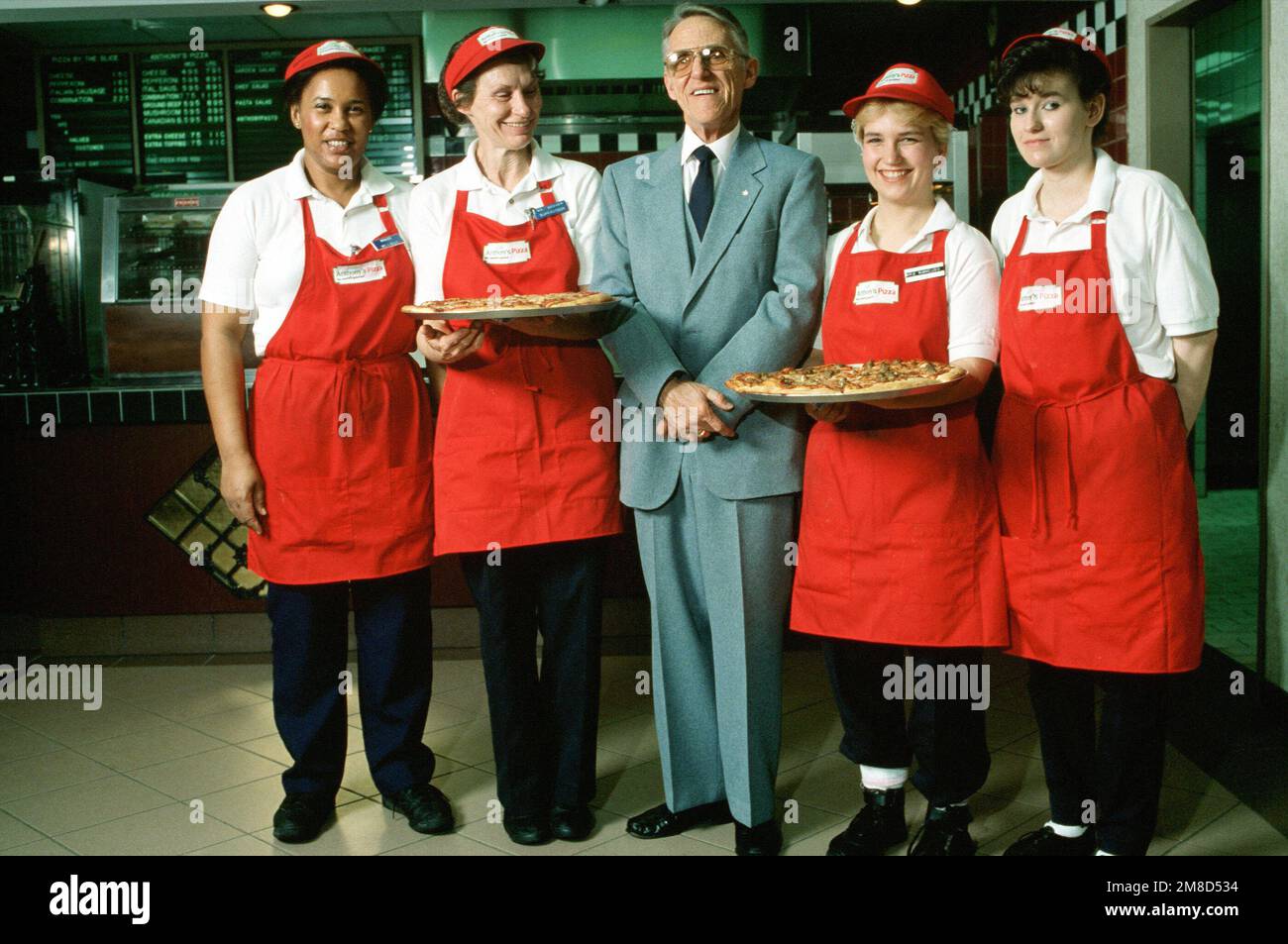 The staff of a pizza shop poses for a photograph with the manager of ...