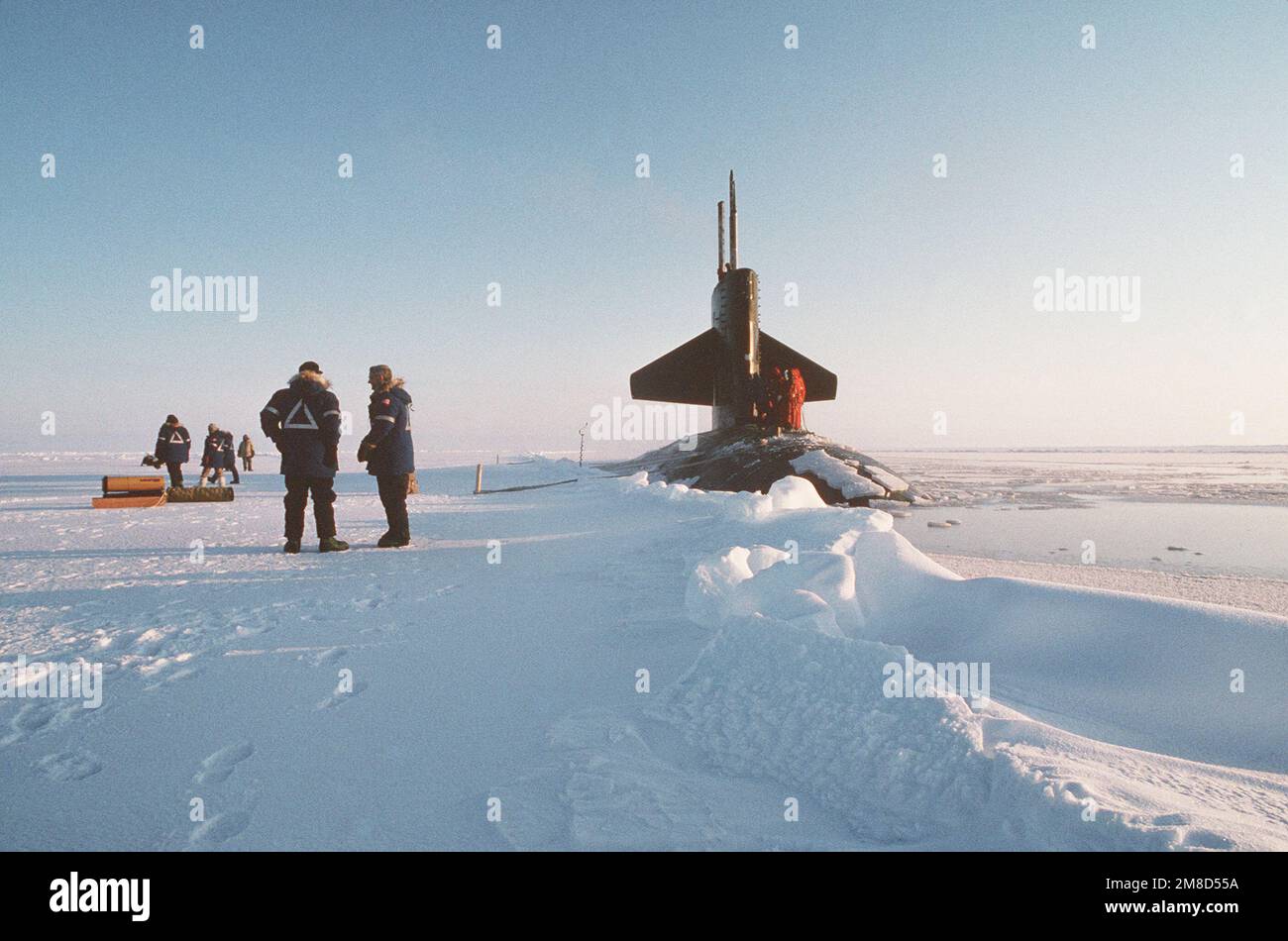 Crew members stand near the nuclear-powered attack submarine USS ...